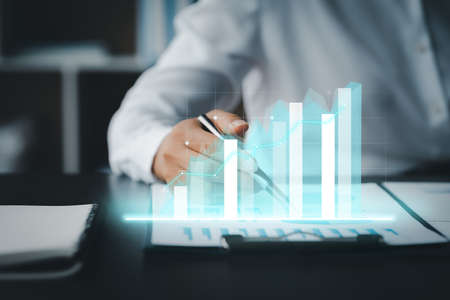 A businesswoman examines data on financial documents, company financial ...