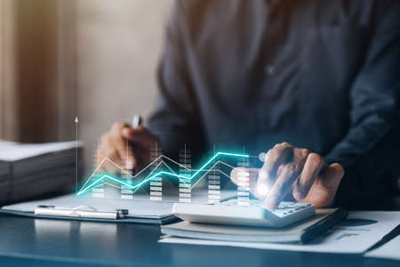 A businessman examines data on financial documents, company financial ...