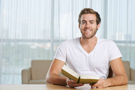 Handsome smiling man reading a book Images - Search Images on Everypixel