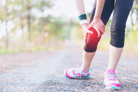 Running sport injury . Female athlete runner touching foot in pain due ...
