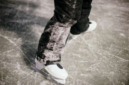 legs with skates on ice close up view, on night track - Stock Image ...