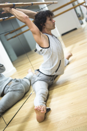 Man dancer dance teacher stetching in gym fitness studio doing advanced ...