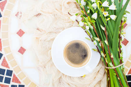 Bouquet White spring bellflowers and coffee cup on table in garden ...