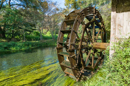 Water mill wheel on river on sunny day. Sustainable energy and water ...