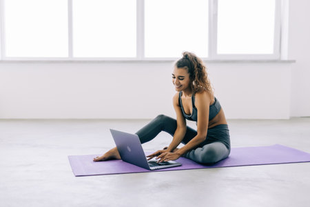 Young healthy woman meditating watching live online tv pilates class ...