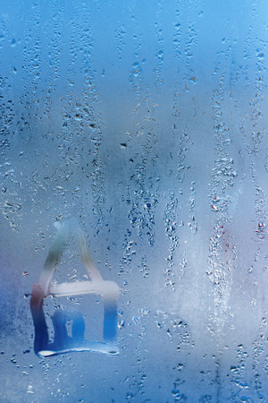 Hand draw on glass and water drop. Condensation and raindrops on a ...