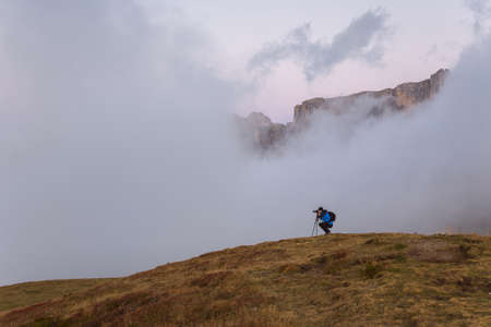 Photographer taking a picture the sunset over the Dolomites Alps-Italy ...