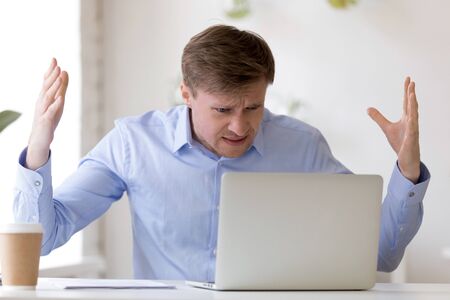 Angry middle aged businessman looking at laptop screen, dissatisfied ...