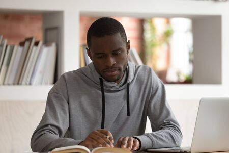 Focused male african american student preparing for final examination ...