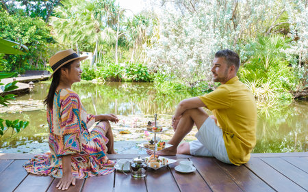 Afternoon tea at a water pond, high tea in a tropical garden in ...