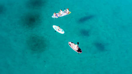 Happy Family on SUP stand up paddle on vacation. Aerial shot of Active ...