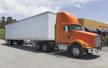Side view of parked semi truck with orange cab. - Stock Image - Everypixel