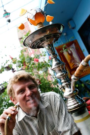 Man smoking a traditional Middle Eastern Hookah.の写真素材 [40004613083 ...