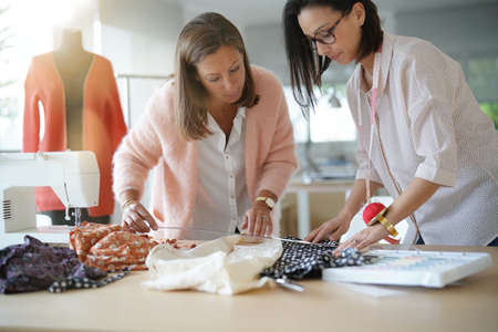 Women designers in workshop working on clothe pattern - Stock Image ...