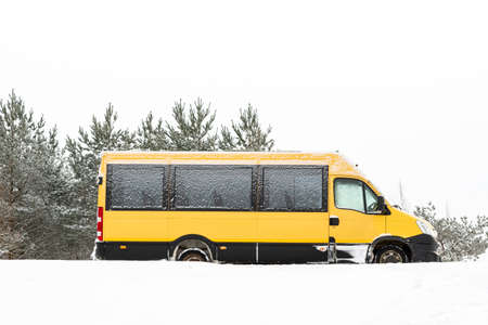 School bus covered with fresh snow. Minibus under the snow. Sleet slush ...