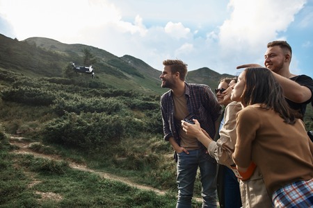 Funny dron. Positive emotional young people traveling in the mountains ...