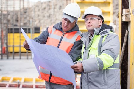 Civil engineer And Foreman at construction site are inspecting ongoing ...