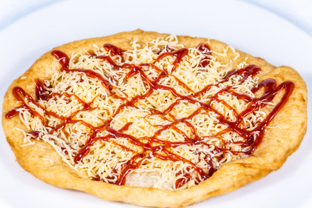Langos stuffed with grated cheese and dressing.Langos is a traditional ...