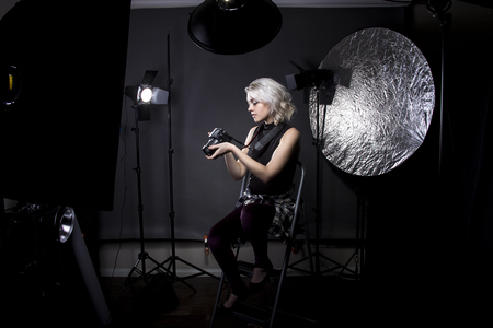 Creative female professional photographer in a strobe lighting studio ...