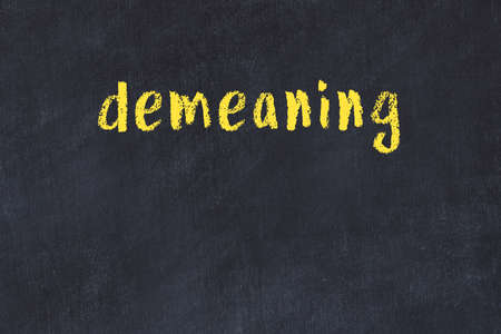 Chalk handwritten inscription demeaning on black deskの写真素材 [40185061386 ...