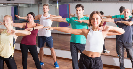 Young positive people studying zumba elements in dancing hallの素材 ...