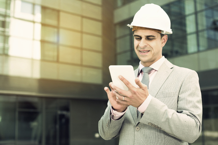 Successful businessman using phone outdoor near large factory - Stock ...