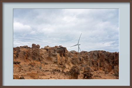 Modern wind turbines in a petrified limestone forest in a photo frameの ...