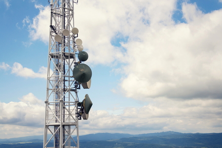 Aerials and transmitters on telecommunication tower with mountains in ...
