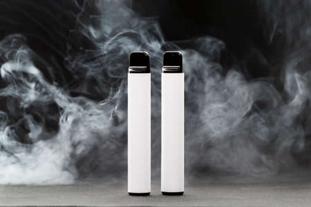 E-cigarettes on dark background in smoke, mocap, front viewの写真素材 ...