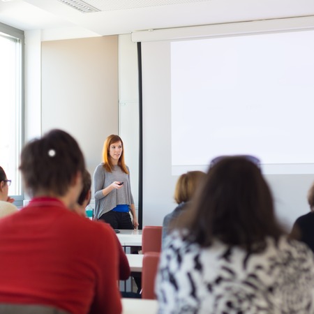 Speaker giving presentation in lecture hall at university. Participants ...
