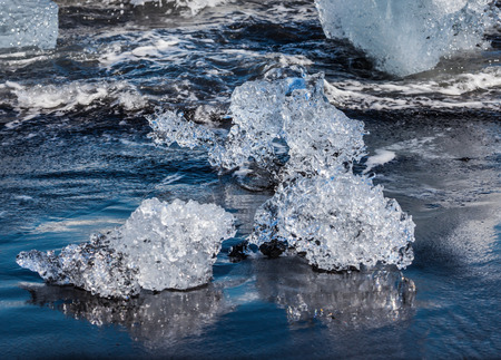 Ice shards of icebergs on wet sand of the shore. Iceland, Jokulsarlon ...