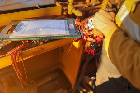 Close up miner hand placing personal red danger lock which is attached ...