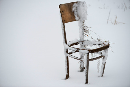 Abandoned, broken, broken-down old wooden chair in the winter in nature ...