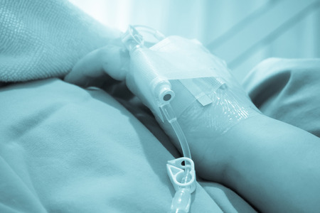 Asian woman patient hand on IV drip with saline solution, fluid ...