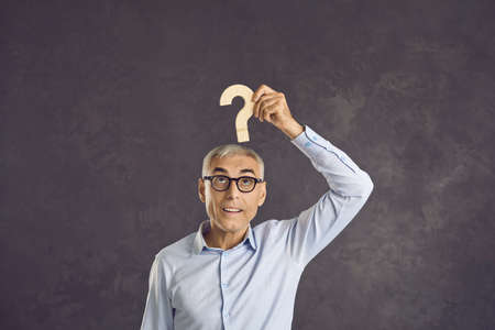 Studio portrait of curious intelligent old senior man looking at ...