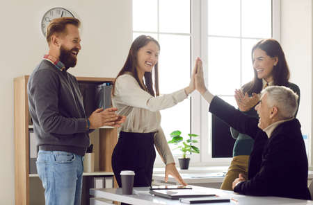 Overjoyed colleagues give high five celebrate shared business success ...