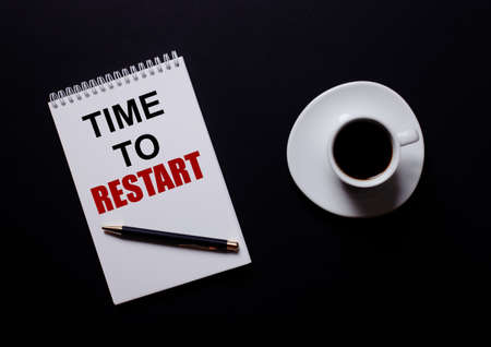 TIME TO RESTART is written in a white notebook in red type near a white ...