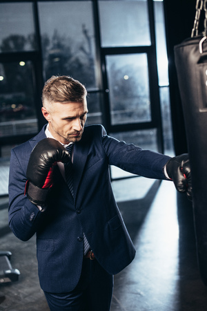 handsome businessman in suit boxing in gym - Stock Image - Everypixel