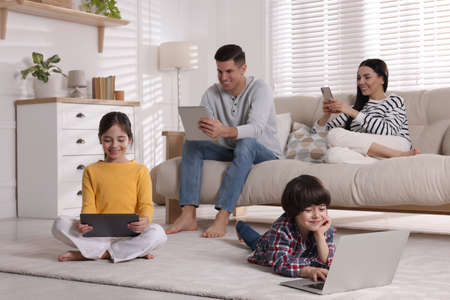 internet addiction. Family with different gadgets in living room ...