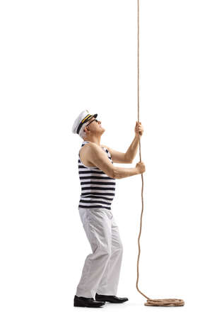 Full length profile shot of a sailor pulling a rope isolated on white ...