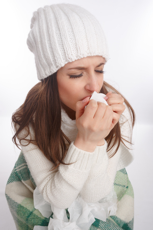 Sick young woman in pajamas scarf and hat coughing and blowing ...