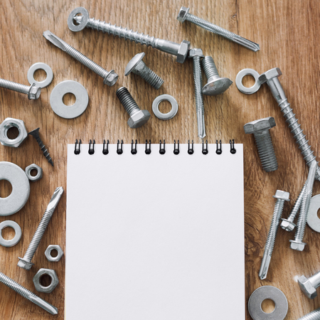 Construction tools. The screws, nuts and bolts arranged around blank ...