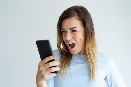 Angry woman shouting at smartphone. Indignant lady using device ...