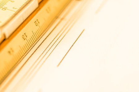 Schemes and slide rule on the table. Angle view close-up, in yellow ...