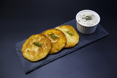 Traditional tasty hash brown with cream sauce on a stone black plate .の ...