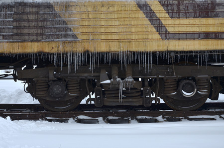Detailed photo of a frozen car passenger train with icicles and ice on ...