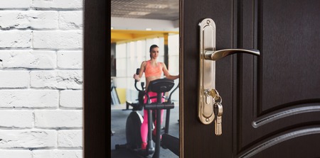 Opened door to modern gym interior with equipment. Entrance to fitness ...