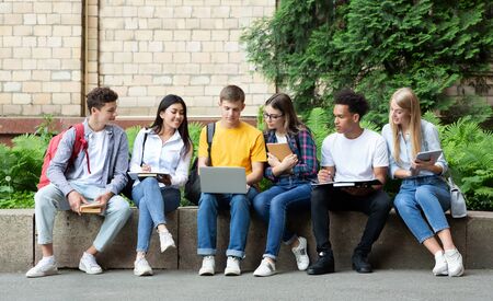 Students life. Friends sitting in university campus with books and ...
