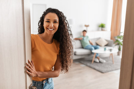 Happy young couple inviting people to enter home - Stock Image - Everypixel