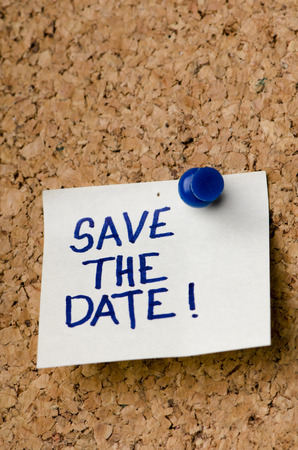 Save the date message on sticker note pin on cork office board ...